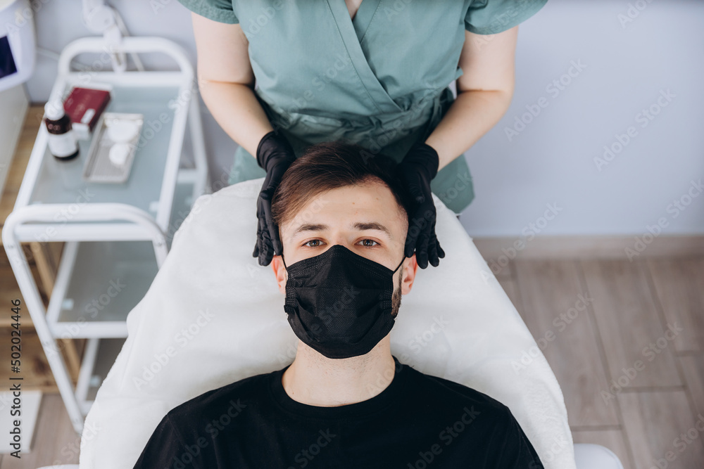 An attractive man receives mesotherapy injections to treat hair loss at ...