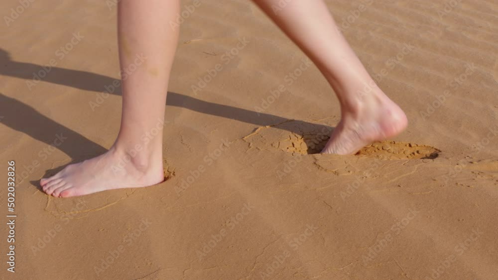 Female legs go on sand in desert. Feet of girl step, are drowning in ...