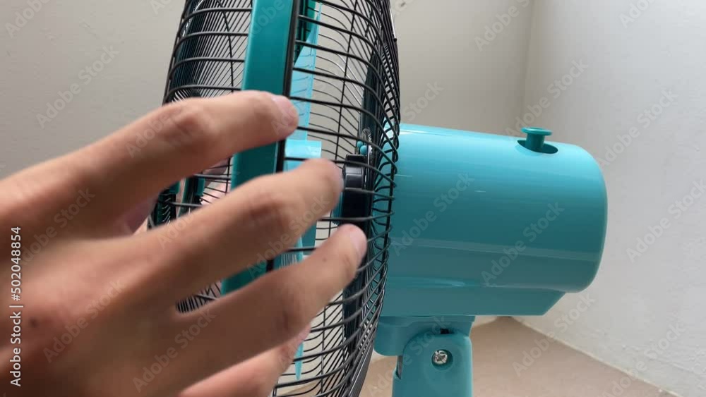 Attaching front grille metal to electric fan. Hand hold black screen ...