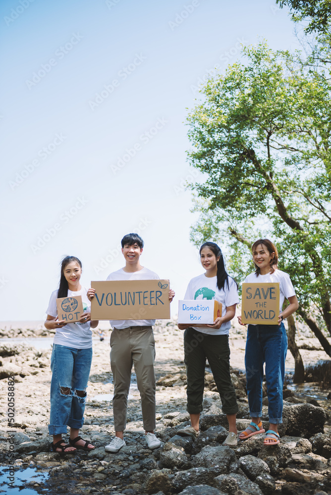 Group of volunteers hold a volunteer sign in world environment day ...