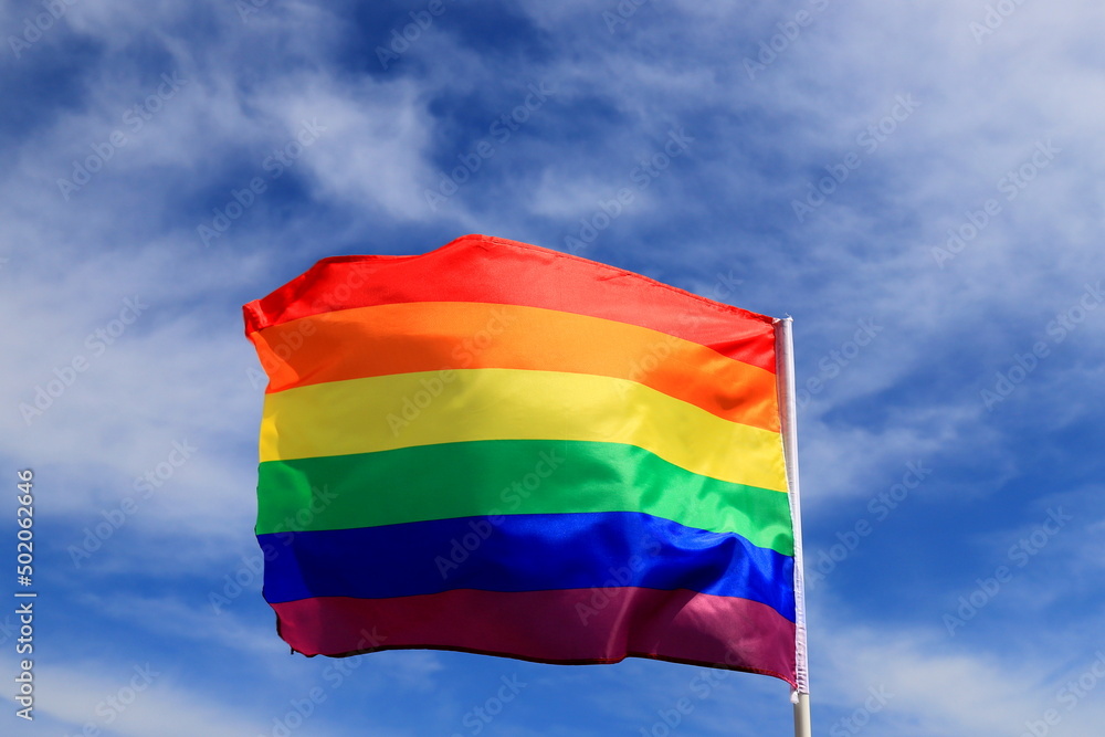 Realistic rainbow flag of LGBT organization waving against sky. LGBT ...