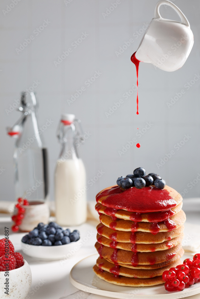 Coulis de fruits rouges sur les pancakes. Crêpes sur une assiette ...