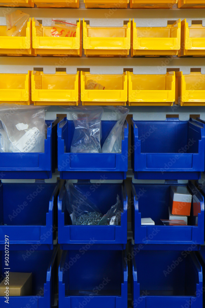 Plastic hanging boxes in yellow and blue colors for storing small parts ...