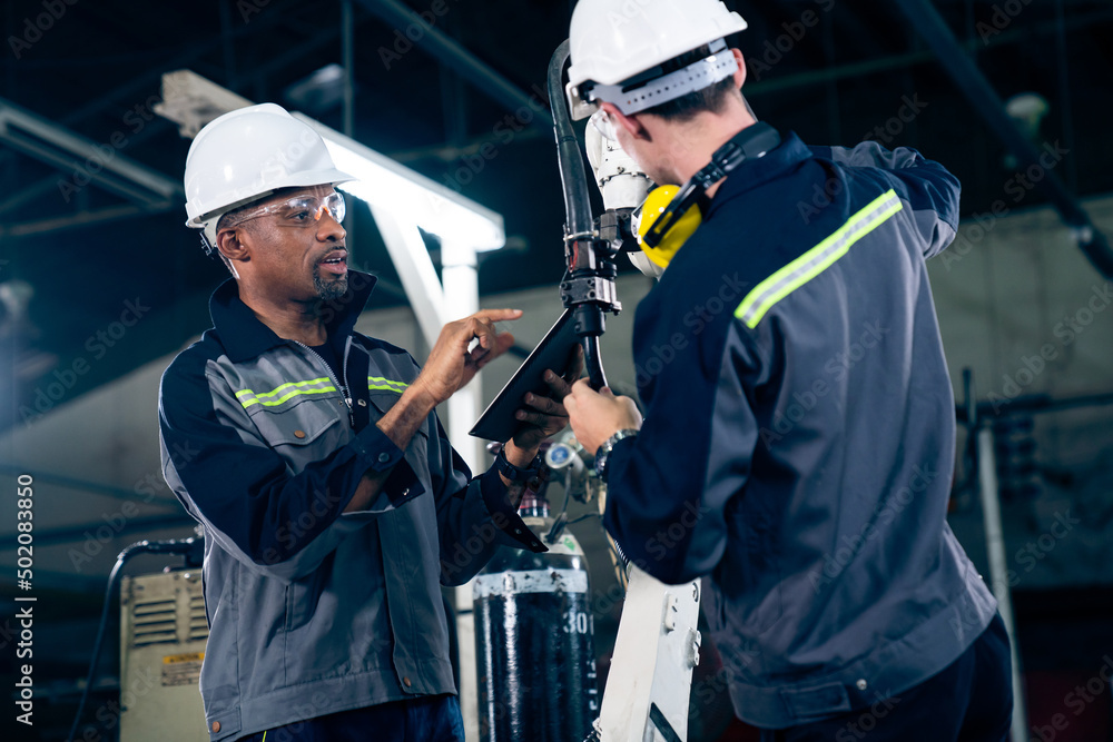 Factory workers working with adept robotic arm in a workshop . Industry ...
