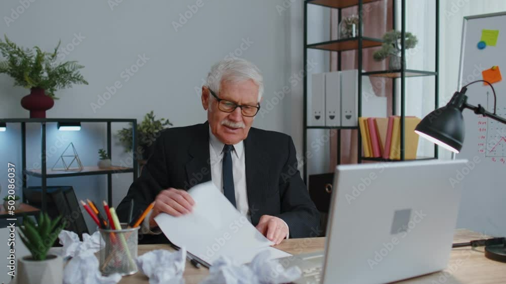 Senior business office man use laptop throwing crumpled paper, having ...