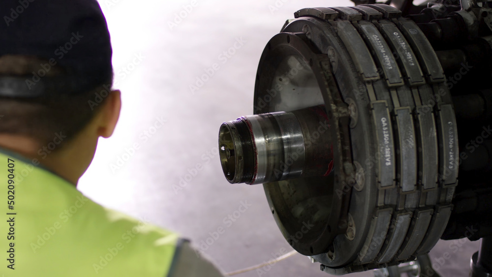 Airport worker checking chassis. Engine and chassis of the passenger ...