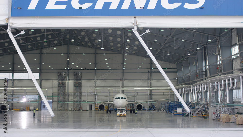 Roller shutter door and concrete floor of airport hangar and airplane ...