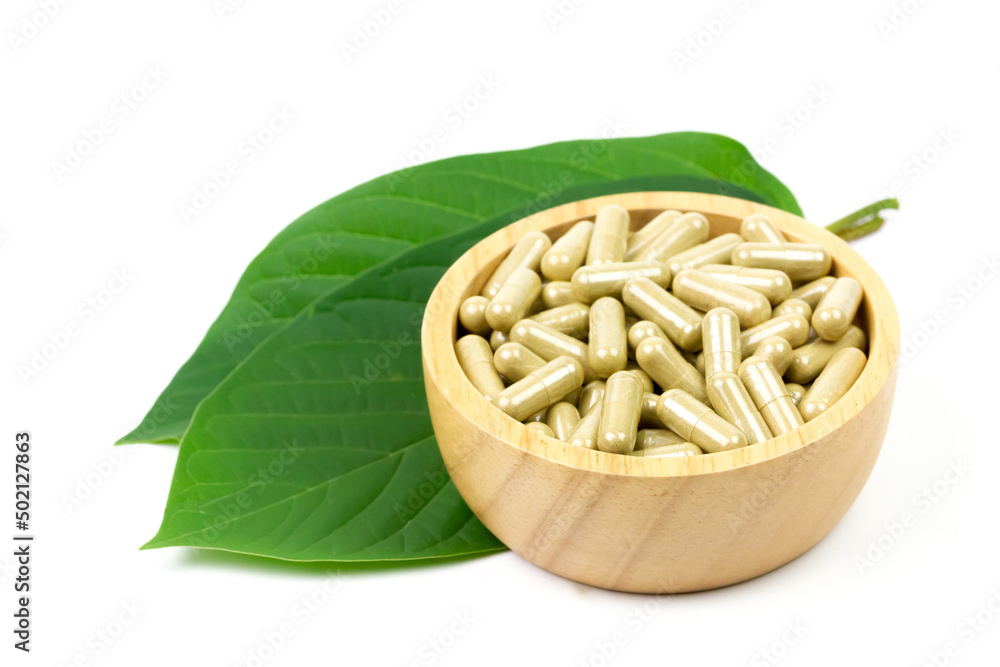 Mitragyna Speciosa Korth or kratom capsules on wooden bowl with green leaf isolated on white ...