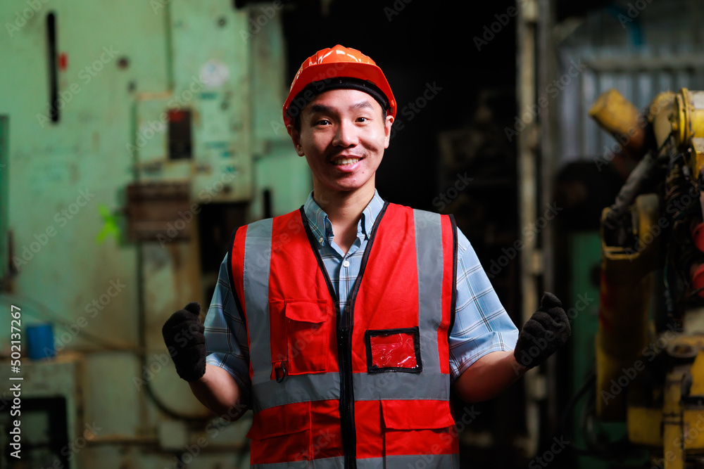 Portrait Happy Asian man worker look at camera thumps up. Metal machine ...