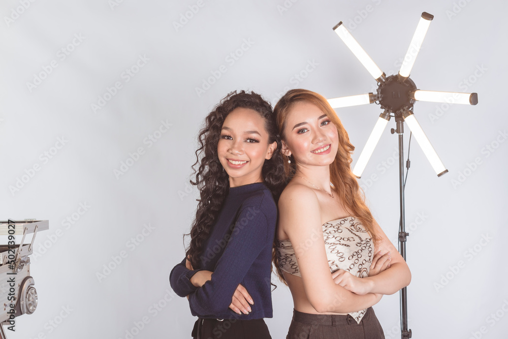 Two attractive asian models posing back to back. Two close friends ...