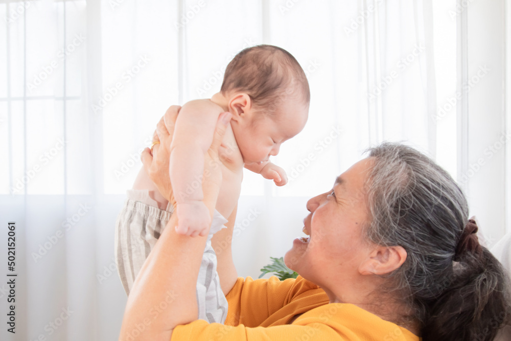 Side view grandmother and newborn baby play together at home, Grandma ...