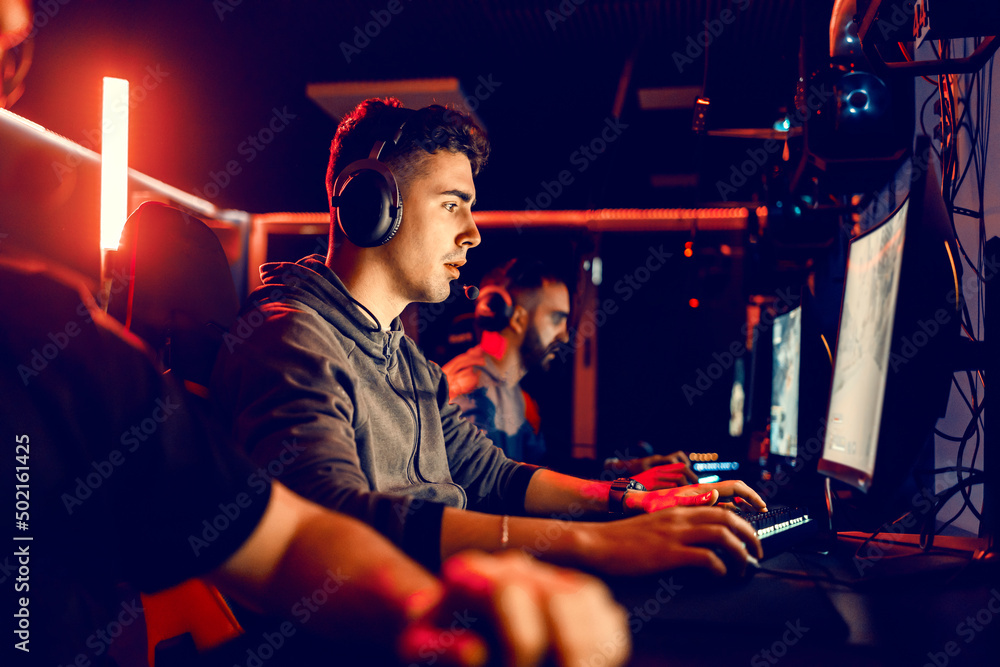 Small group of gamers playing video games in gaming room. Stock Photo ...