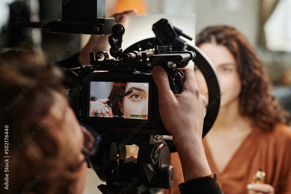 Screen of video camera with part of face of fashion model applying new ...