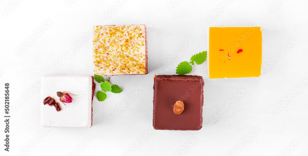 Four assorted cakes on the white table. Mousse cake with passion fruit ...