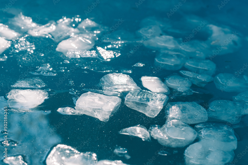 Cold water and ice cubes melting under the sun background. Global ...