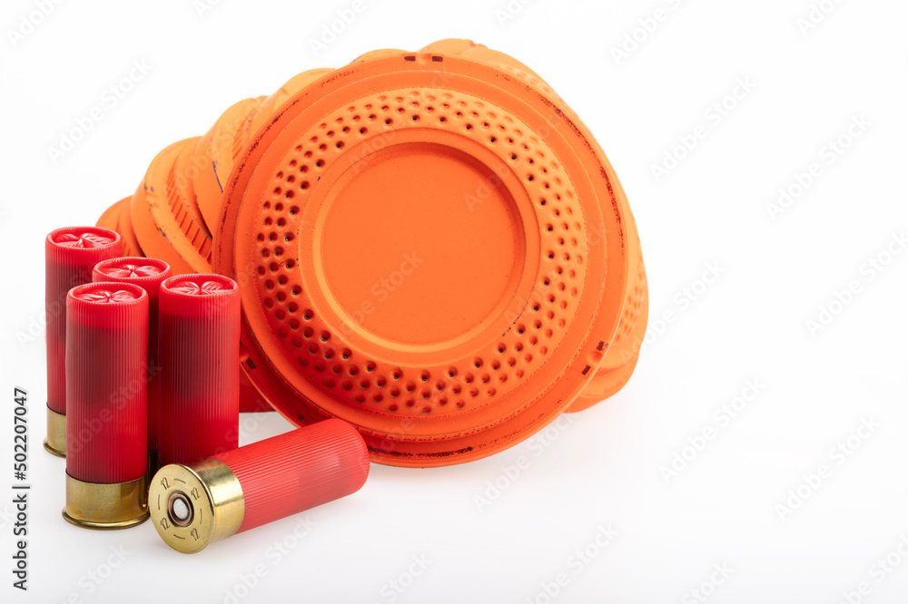 Stack of flying clay pigeon targets and shotgun shell bullets on white ...