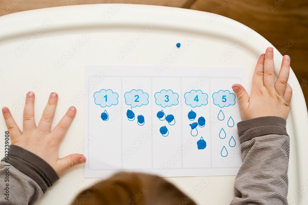 Early education, learning to count. 2 year old boy puts correct amount ...