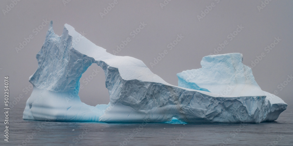 Iceberg in Antarctica with fog around and a good visible see through ...