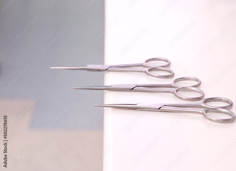 Small sharp surgical scissors placed on table unattended.Image isolated ...
