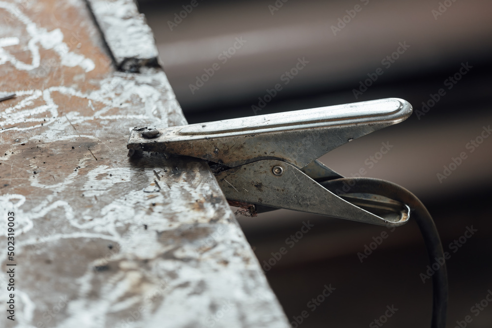 The negative wire of the welding machine with a pin is attached to the ...