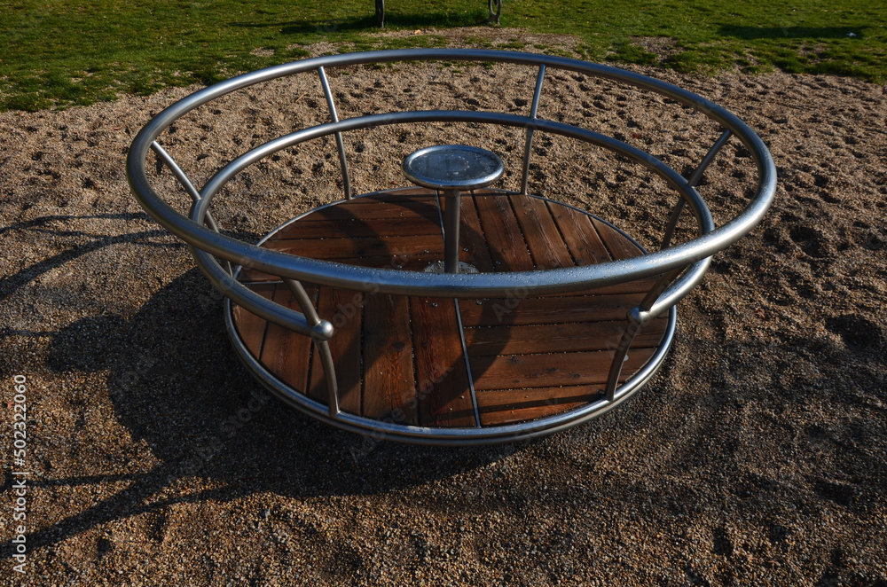 metal carousel with a wooden floor on the playground serves children ...