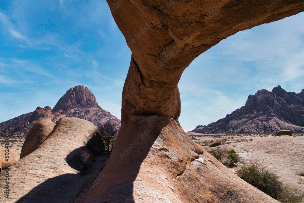 Sitting under the famous stone arch of Spitzkoppe National Park in ...