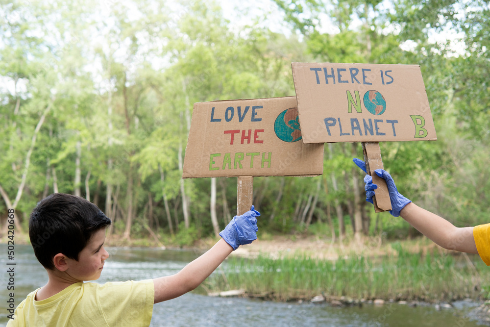 Two arms of a child raising a sign each. Two young brothers with their ...