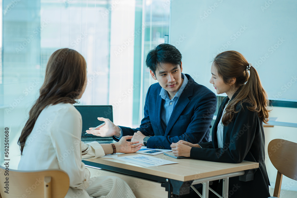 A group of young Asian businessmen working as a team brainstorm ...