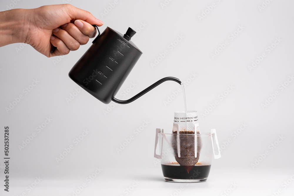 Handing holding black steel long spout drop kettle pouring hot water ...