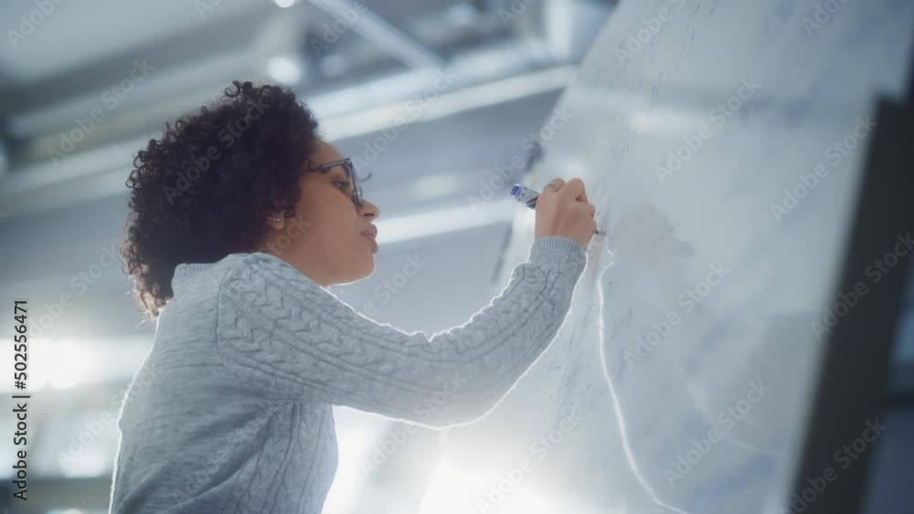 Black Female Scientist Solving Problems and Math Equation while Using ...