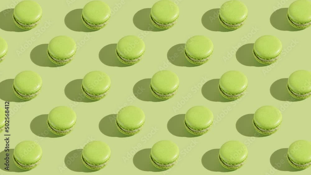 Green macaron pastries photographed on light green paper background ...