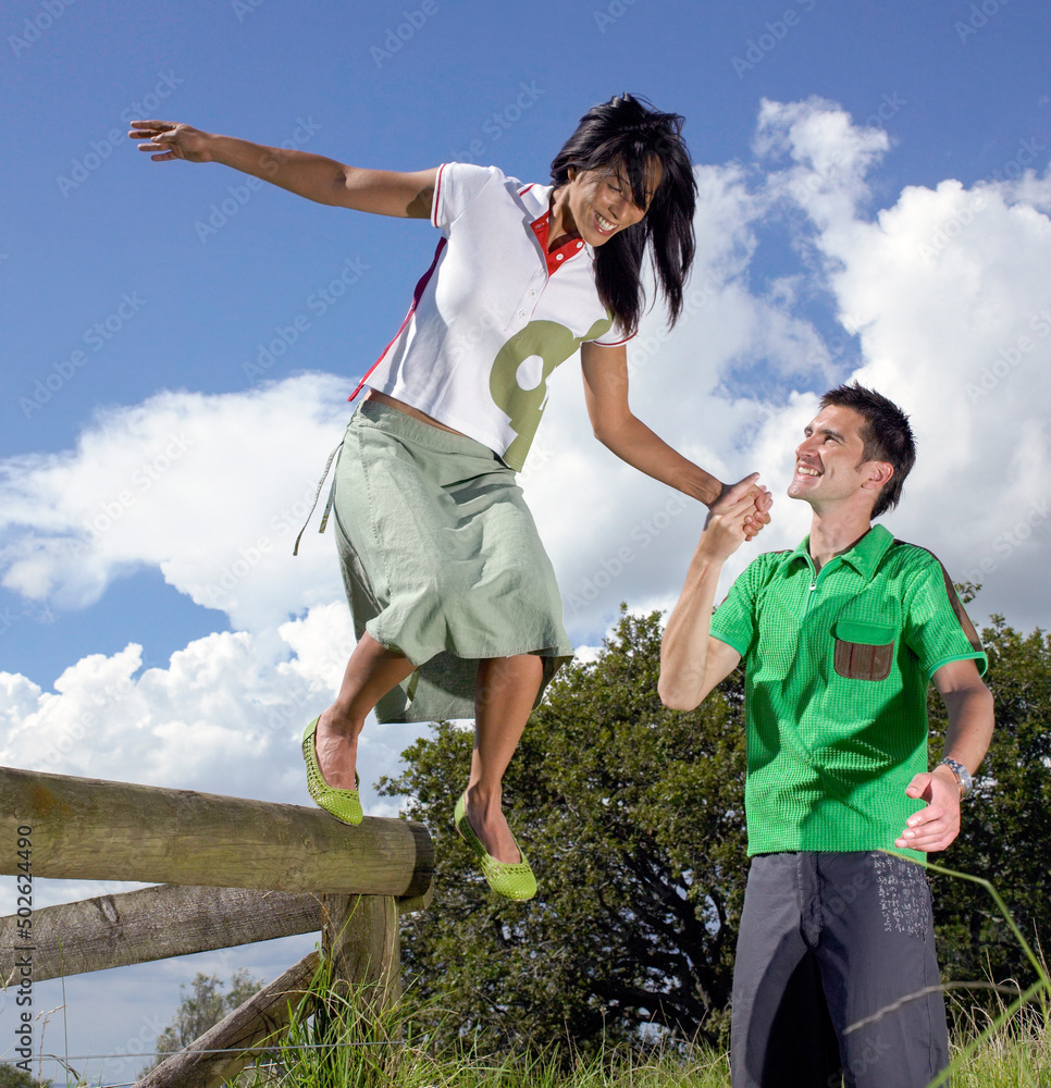 Young man holding young woman's hand as he helps her step down from ...