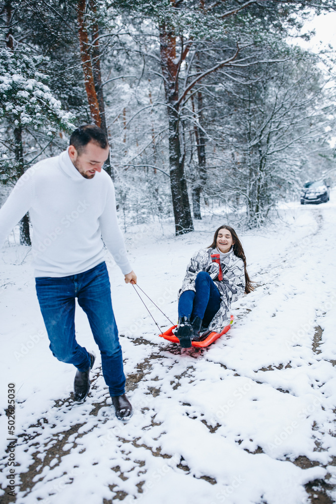 girl in a winter snowy forest sledding. winter fun in the woods. love ...