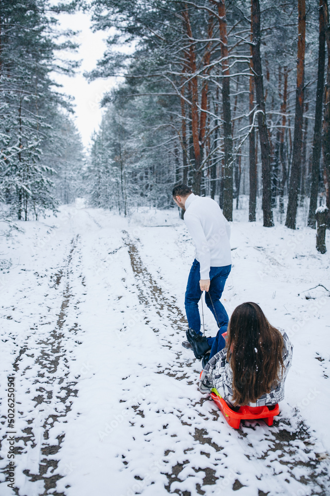 girl in a winter snowy forest sledding. winter fun in the woods. love ...