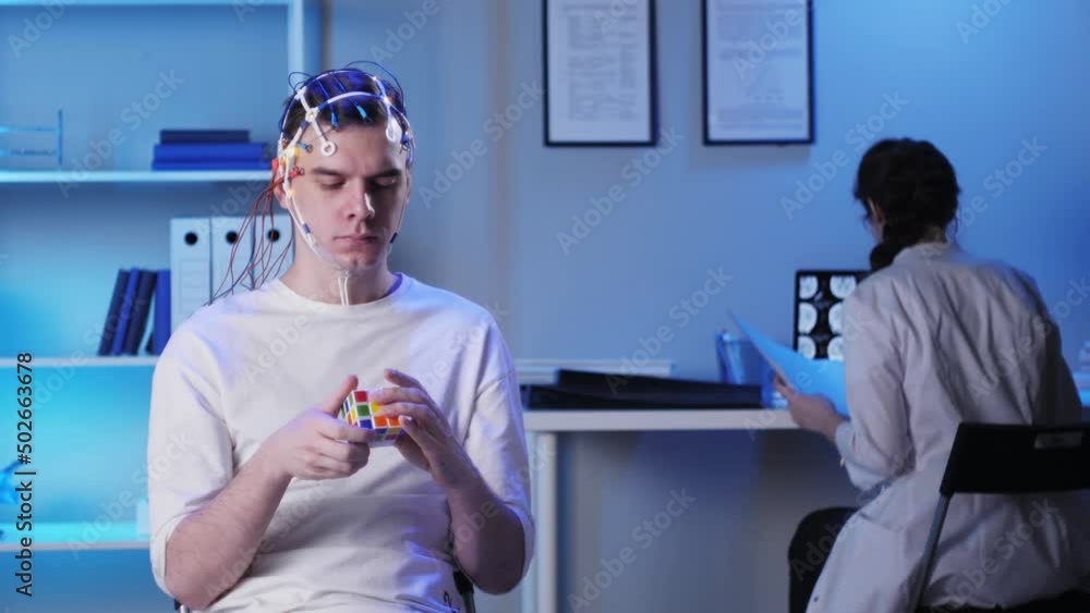 Man wearing EEG topographer for examining brain, doctor making ...