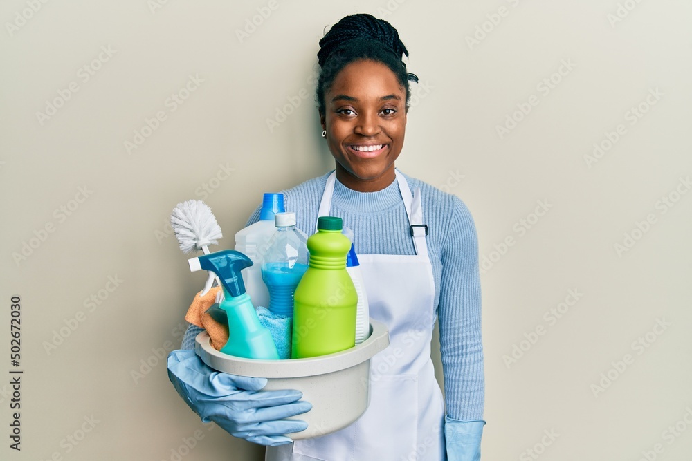 African american woman with braided hair wearing apron holding cleaning ...