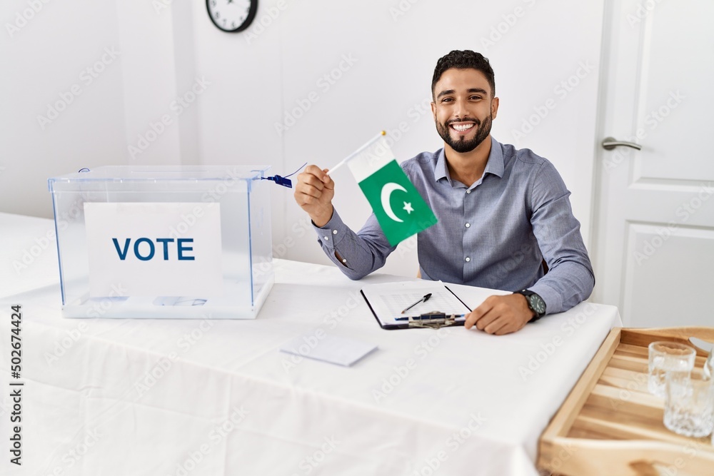 Young handsome man with beard at political campaign election holding ...