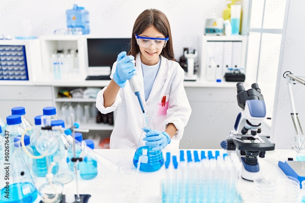 Young hispanic girl working using pipette at laboratory Stock Photo ...