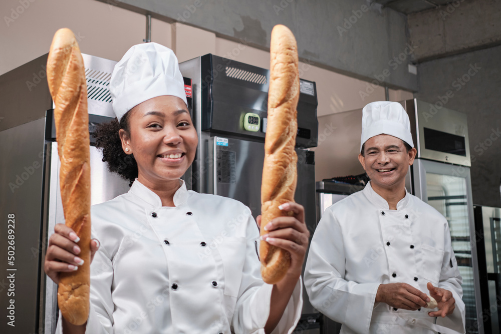 Portrait of professional chefs in white hat uniforms looking at camera ...