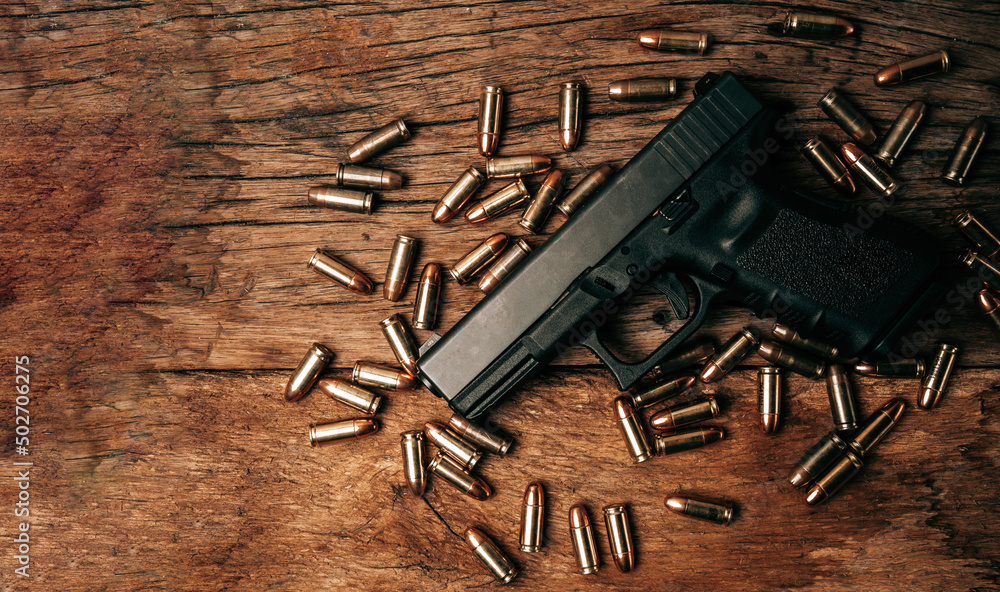 Foto de Portrait of a black 9mm pistol on an old wooden floor with 9mm ...