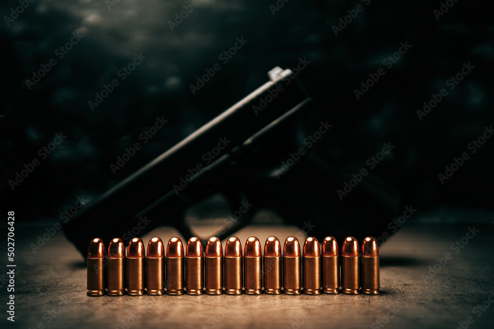 Portrait shots of 9mm bullets lined up on an old concrete floor with a ...