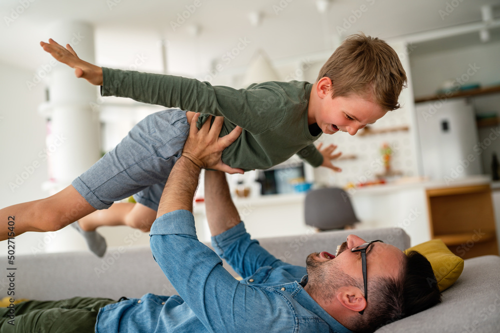 Joyful father and son having fun, spending tim at home together. Single ...