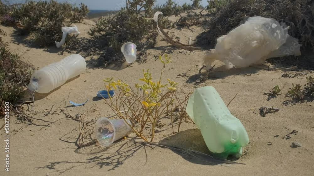 Plastic trash in the desert. Plastic pollution in a sandy desert in ...