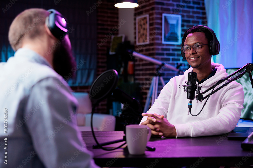 Podcast presenter having live conversation with young man, recording ...