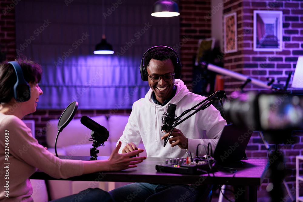 Cheerful people meeting in studio to film podcast episode on camera ...