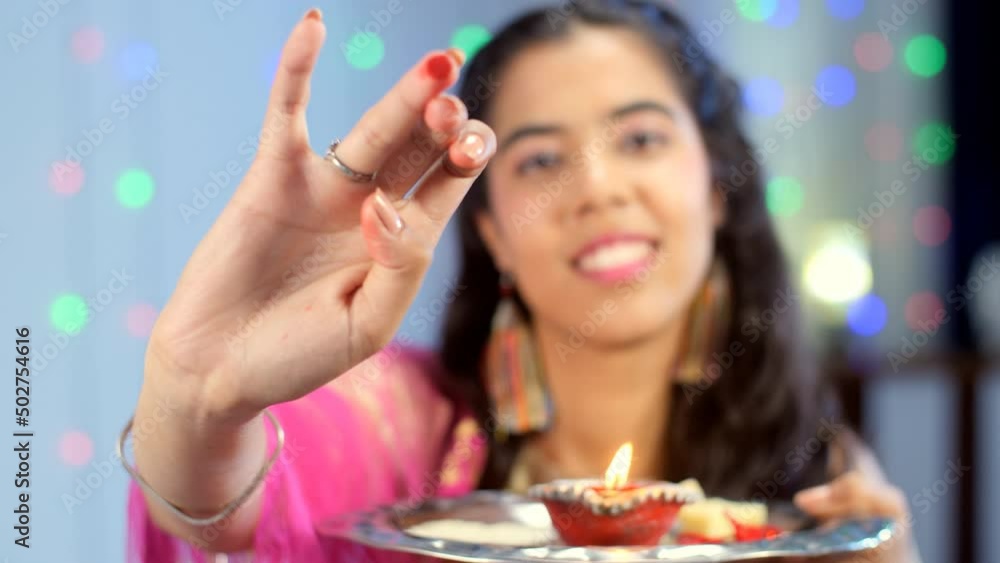 Vídeo do Stock: An attractive young sister in ethnic wear applying a ...