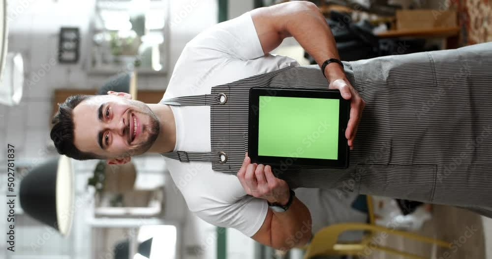Vertical portrait of handsome Caucasian young man waiter in apron ...