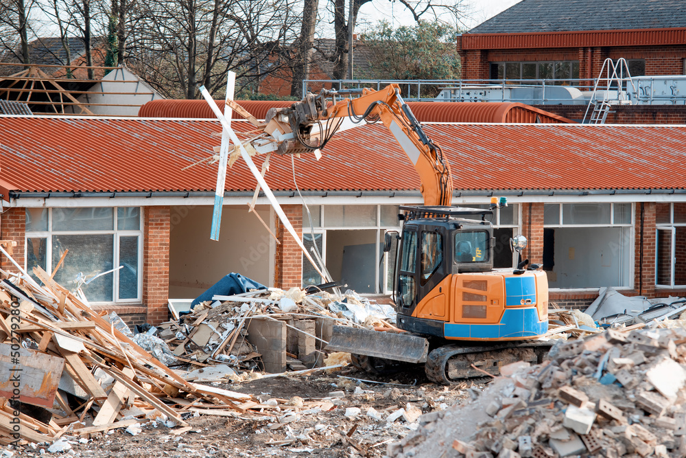 Demolition of an old building with an excavator to give way for a new ...