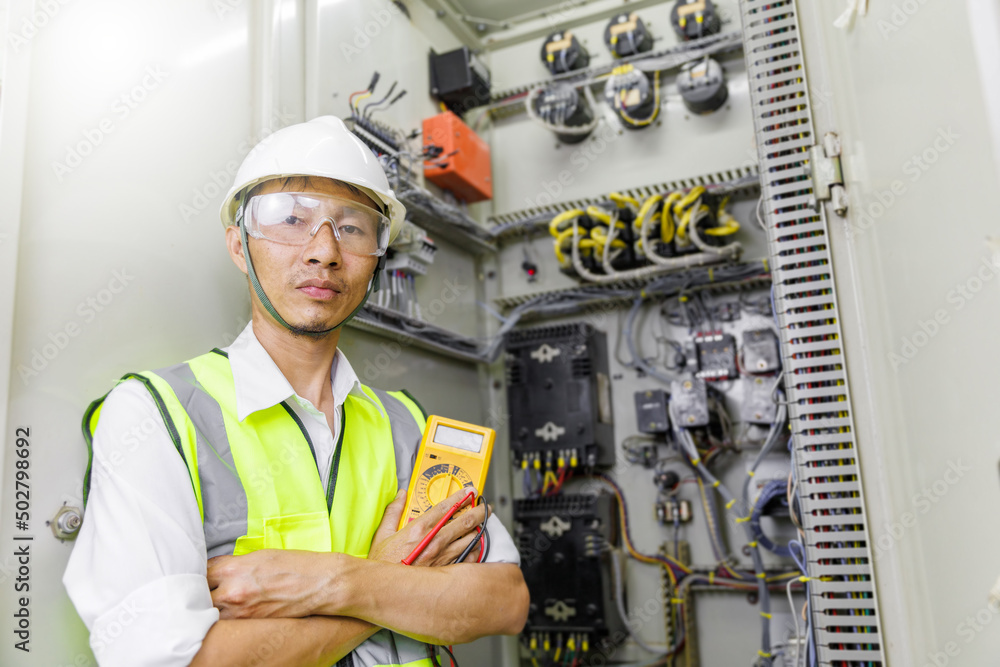 Poster Electrical engineer holding digital multimeter, Electrical ...