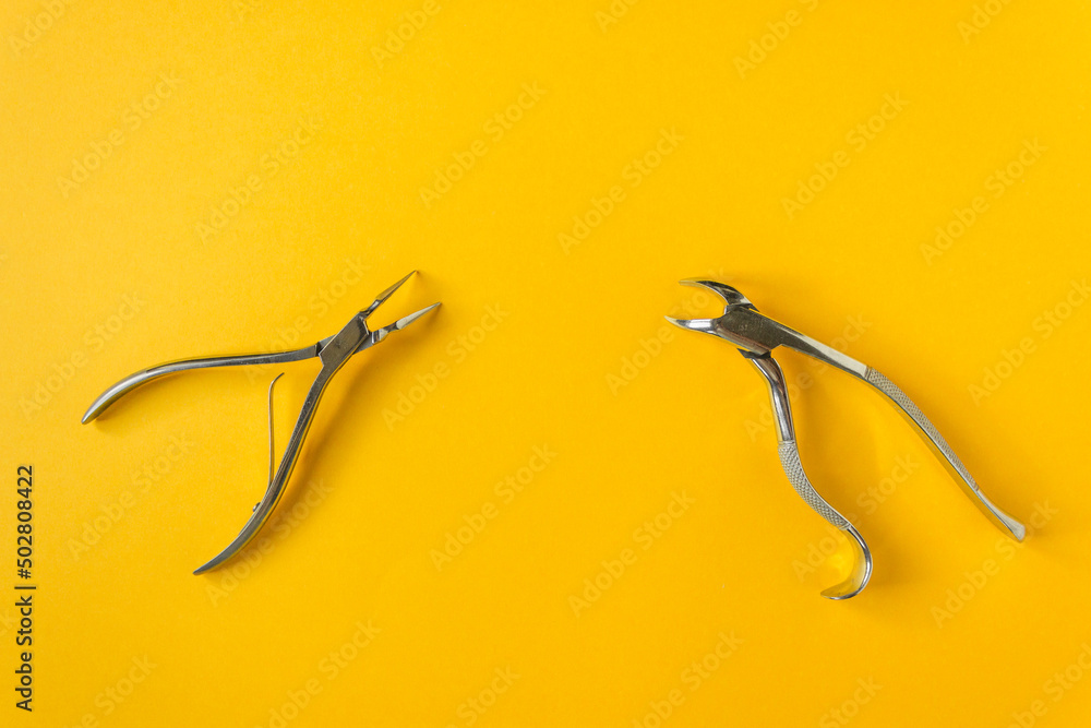 Two dental extraction forceps isolated on the yellow background. For ...